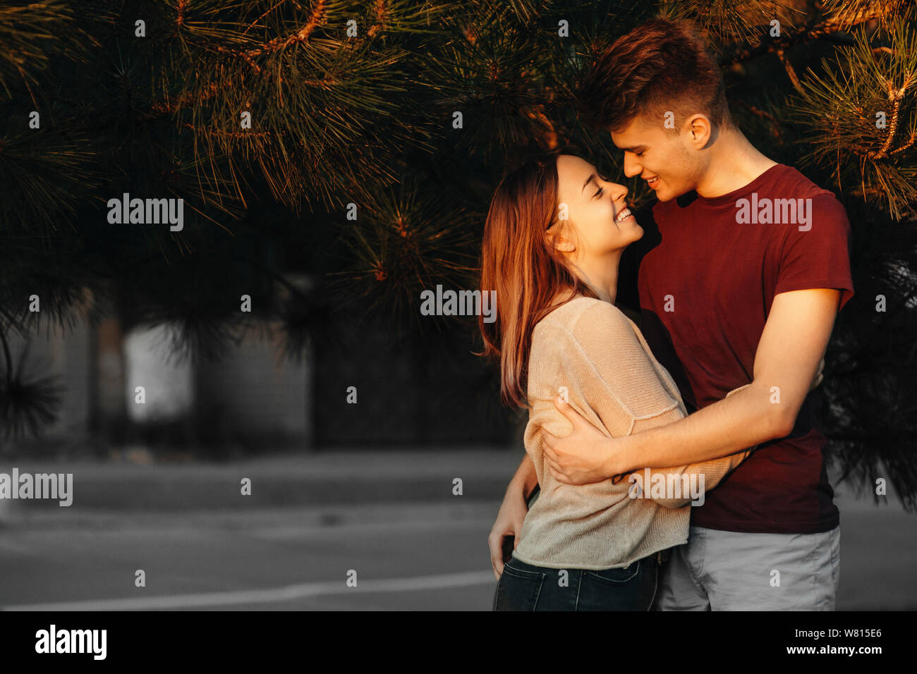 Side view portrait of a cute adult caucasian couple embracing while ...