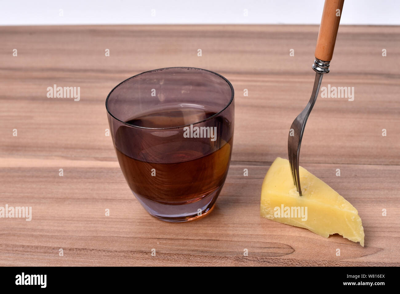 glass of alcoholic drink with cheese on the table on white background ...