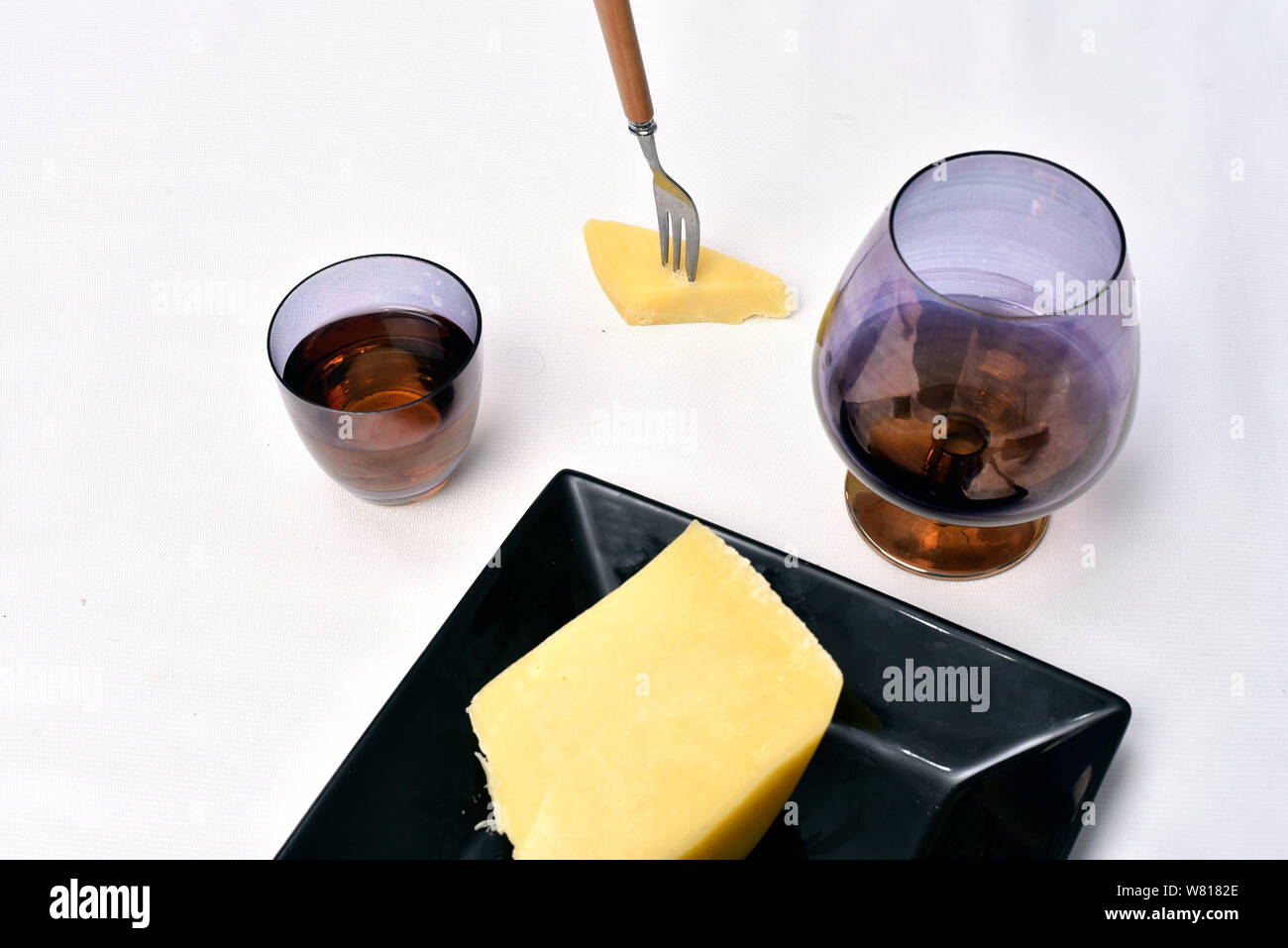 glass of alcoholic drink with cheese on the table on white background ...