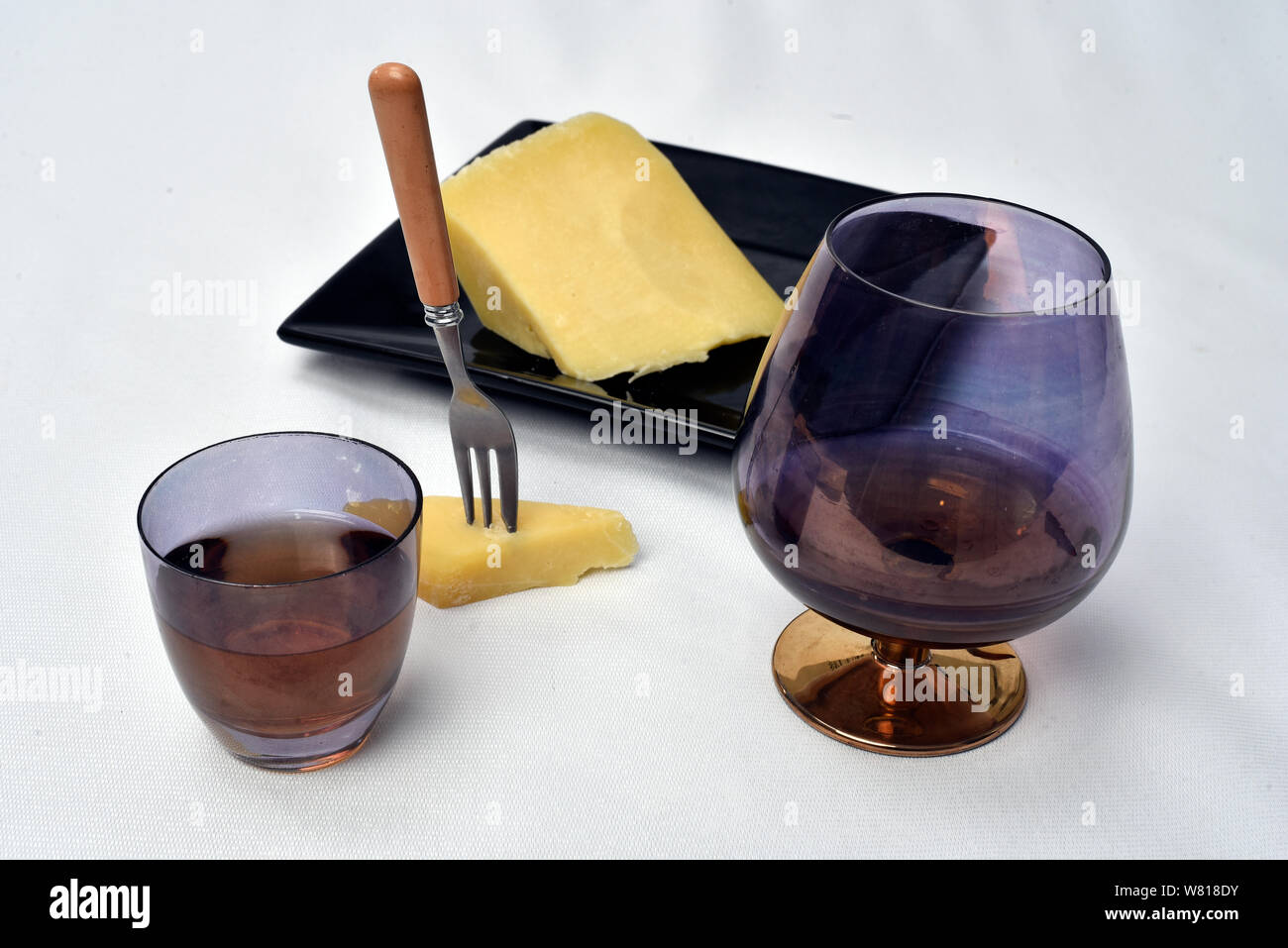 glass of alcoholic drink with cheese on the table on white background ...