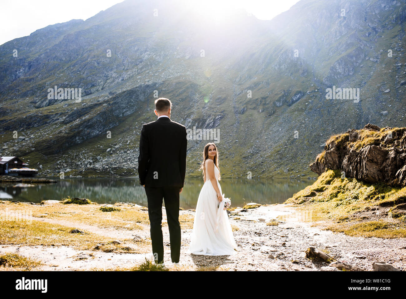 Full length portrait of a lovely young bride looking over the shoulder ...
