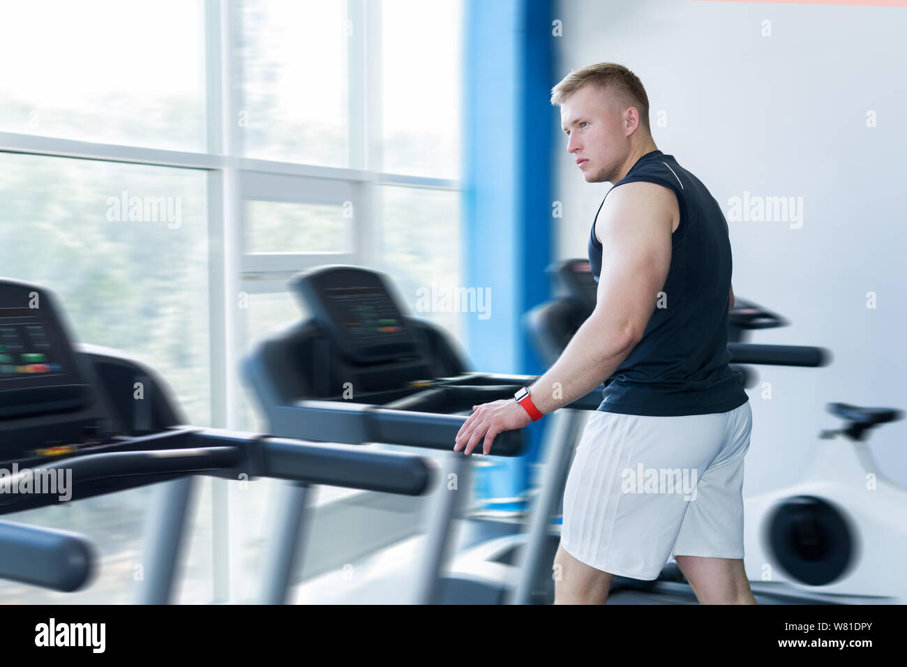 man trains on a treadmill in the gym Stock Photo - Alamy