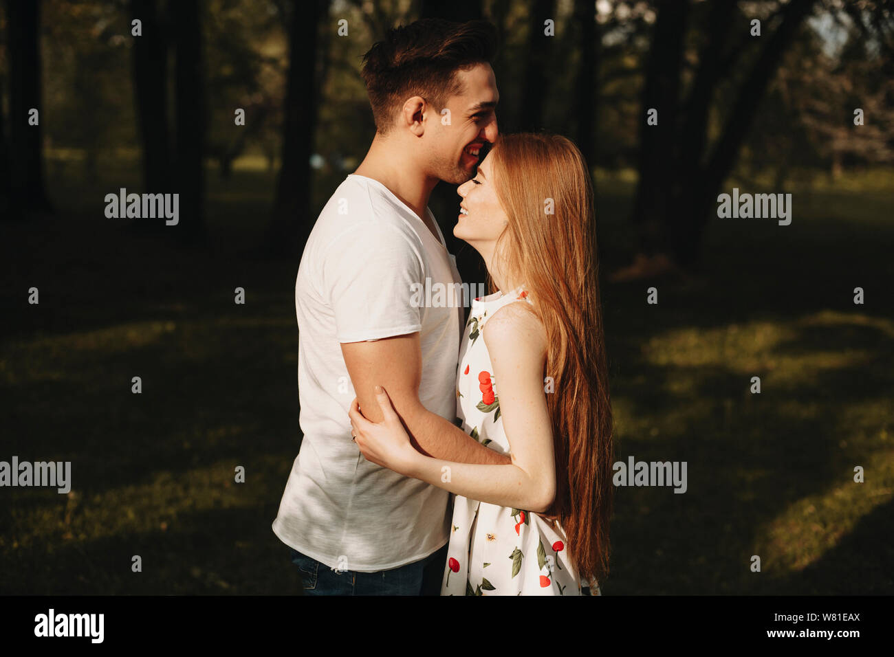 Side view portrait of happy cute couple embracing and smiling before ...
