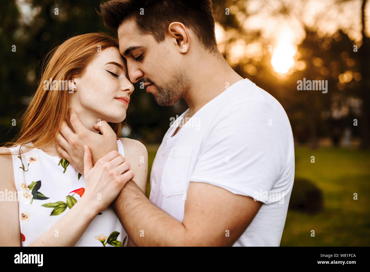 Side view portrait of a amazing caucasian couple embracing and touching ...