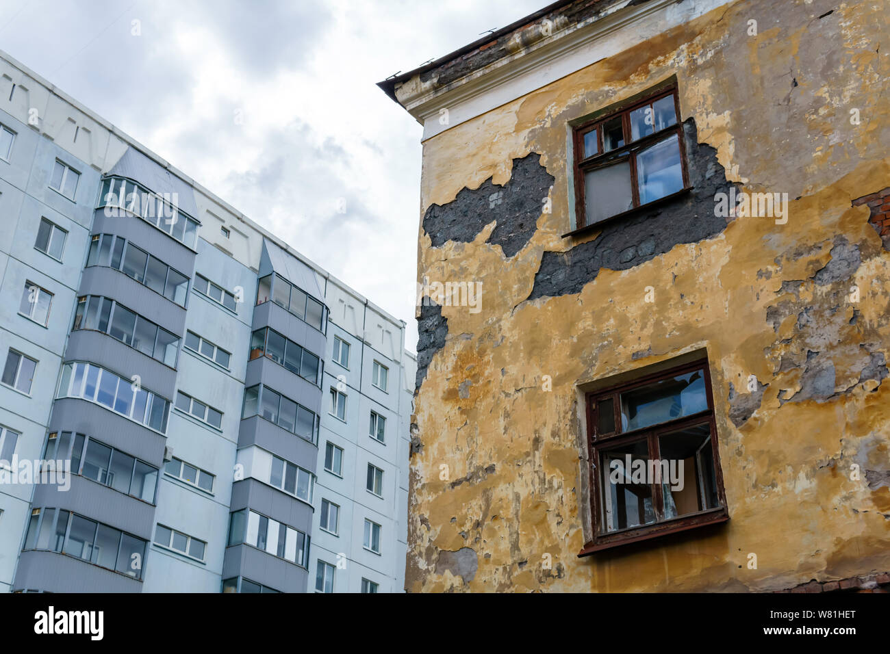 abandoned dilapidated house on the background of a residential multi ...