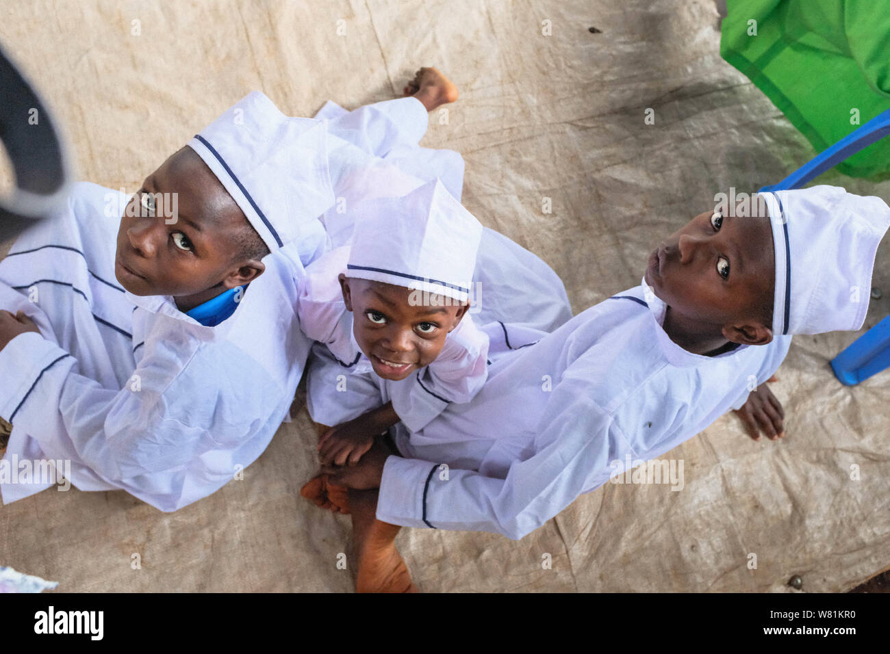 Young kids in prayer gowns at a local church in Kibera.The traditional ...