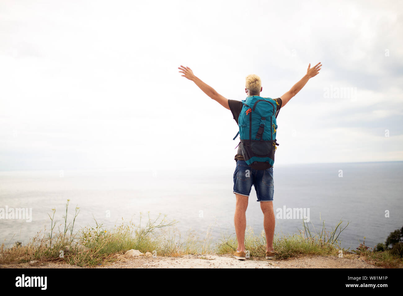 Happy man on mountain enjoying landscape. Travel, vacation, adventure ...