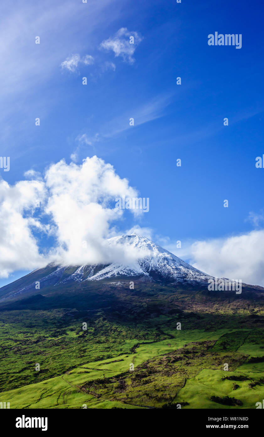 Mount Pico volcano summit and eastern slope under blue sky and clouds ...