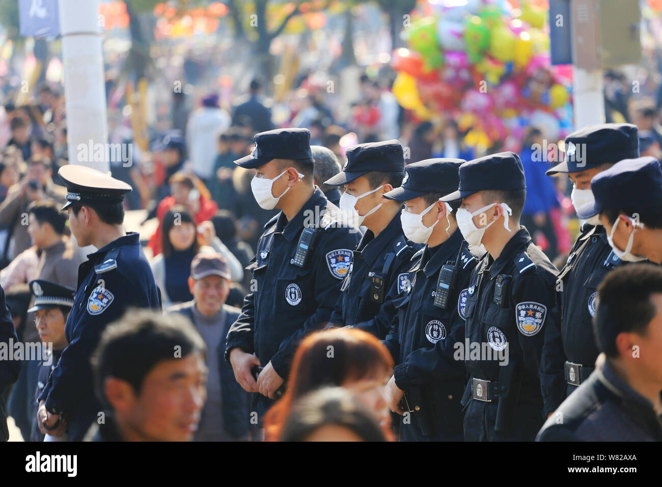 Chinese policemen wearing face masks stand guard as worshippers crowd ...