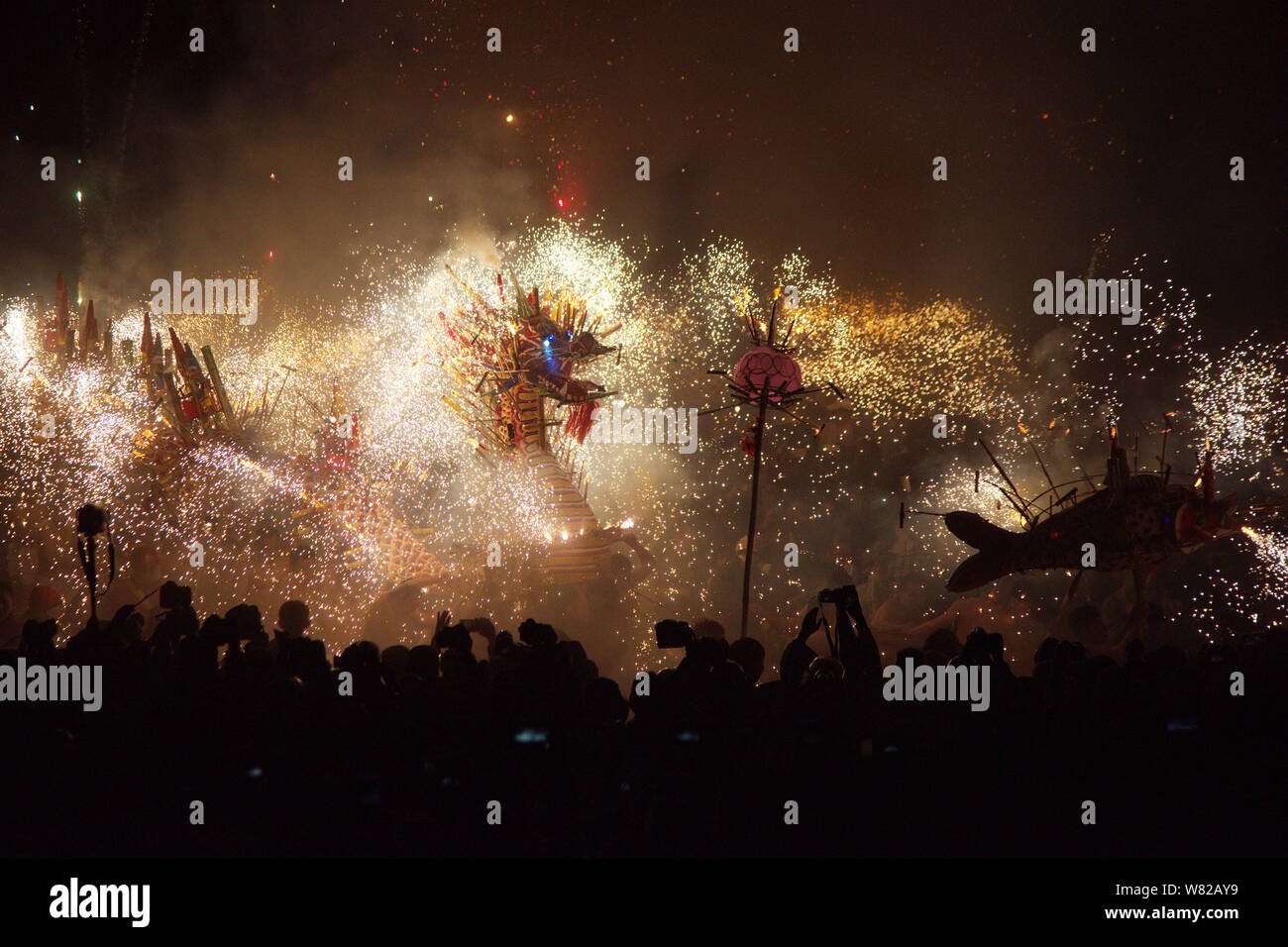 Chinese entertainers perform a dragon dance in sparks of fireworks to ...