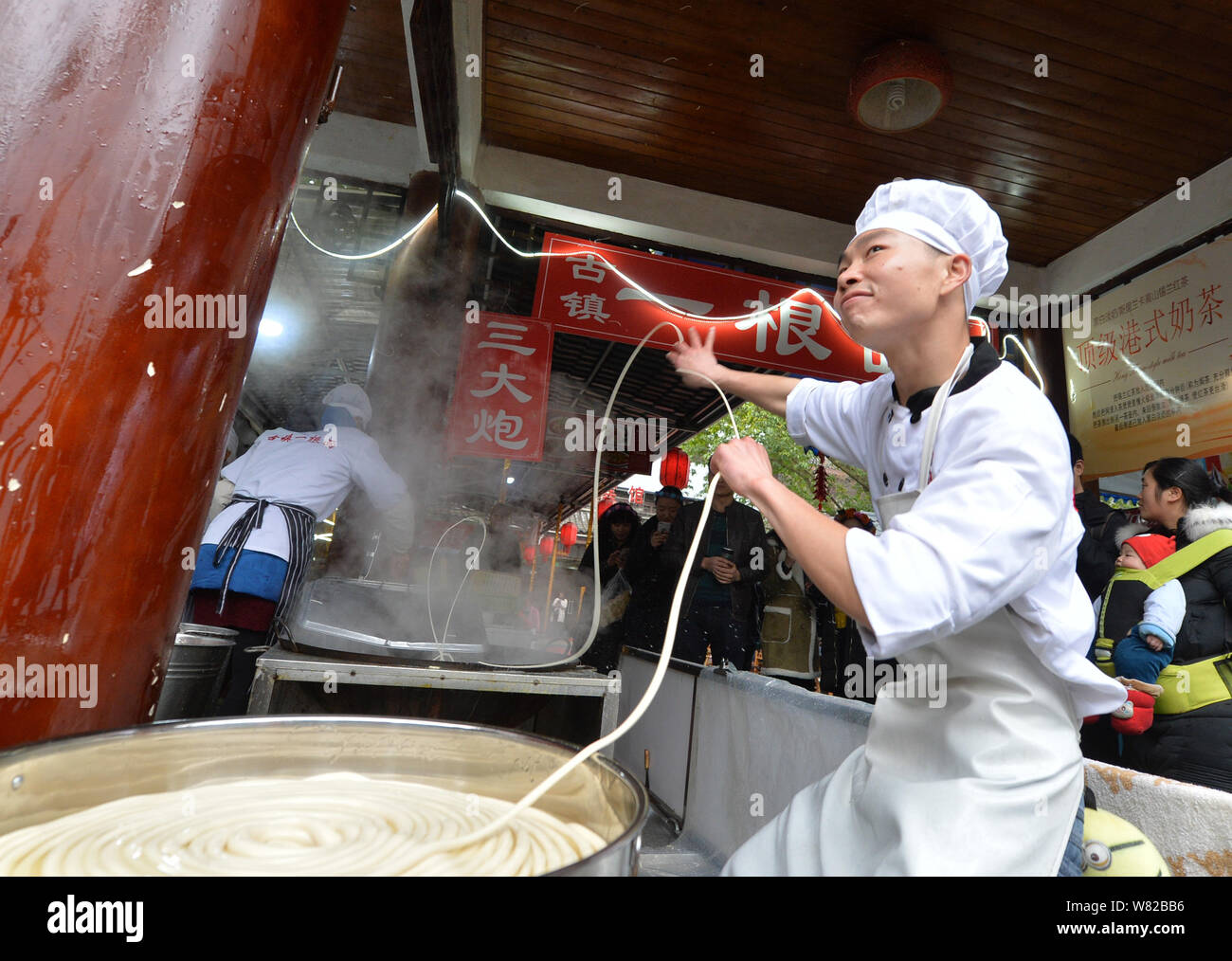 30-year-old Chinese man Tian Bo pulls a one-strand noddle into a ...