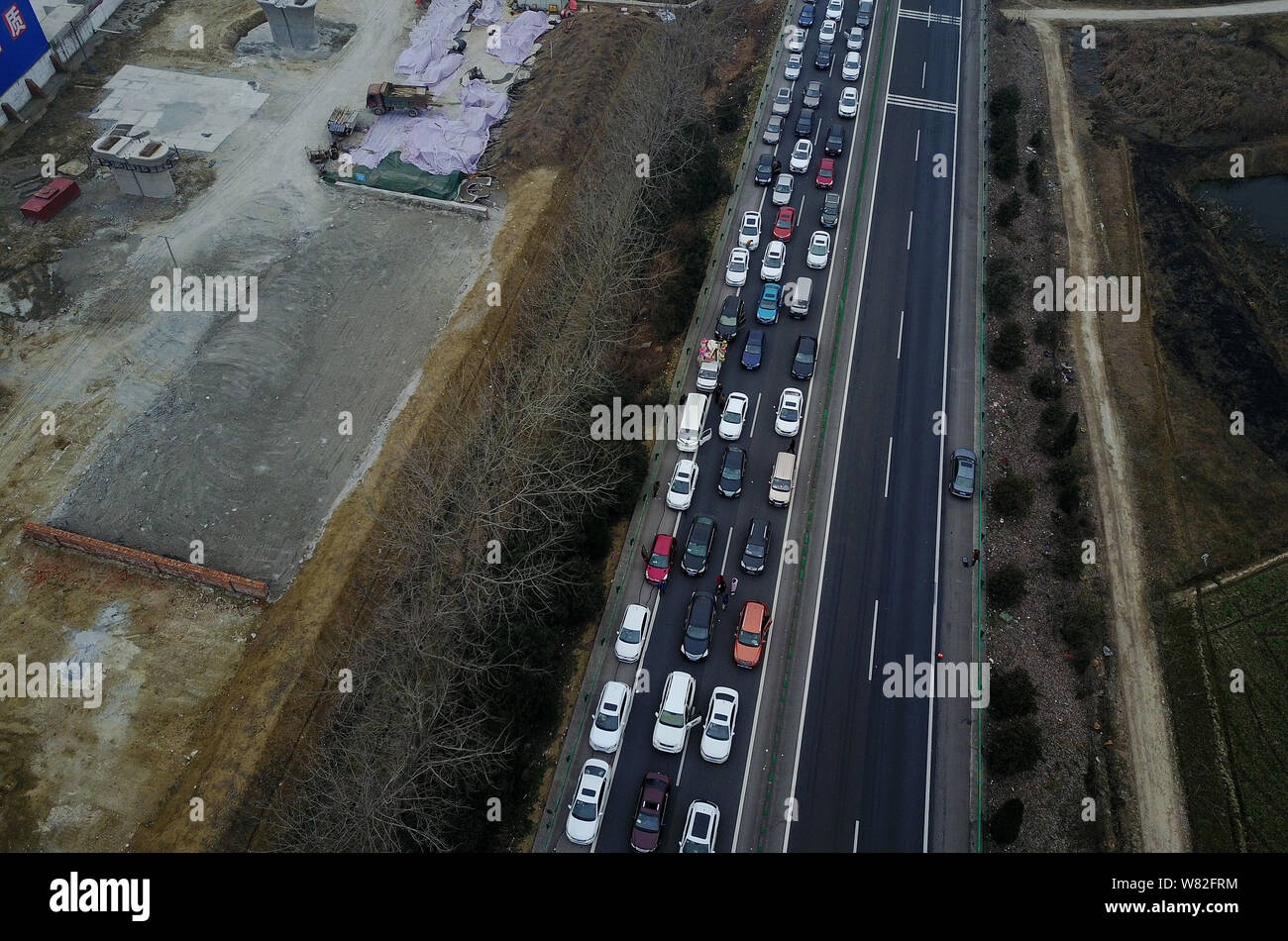 In this aerial view, masses of vehicles queue up to pass through a toll ...