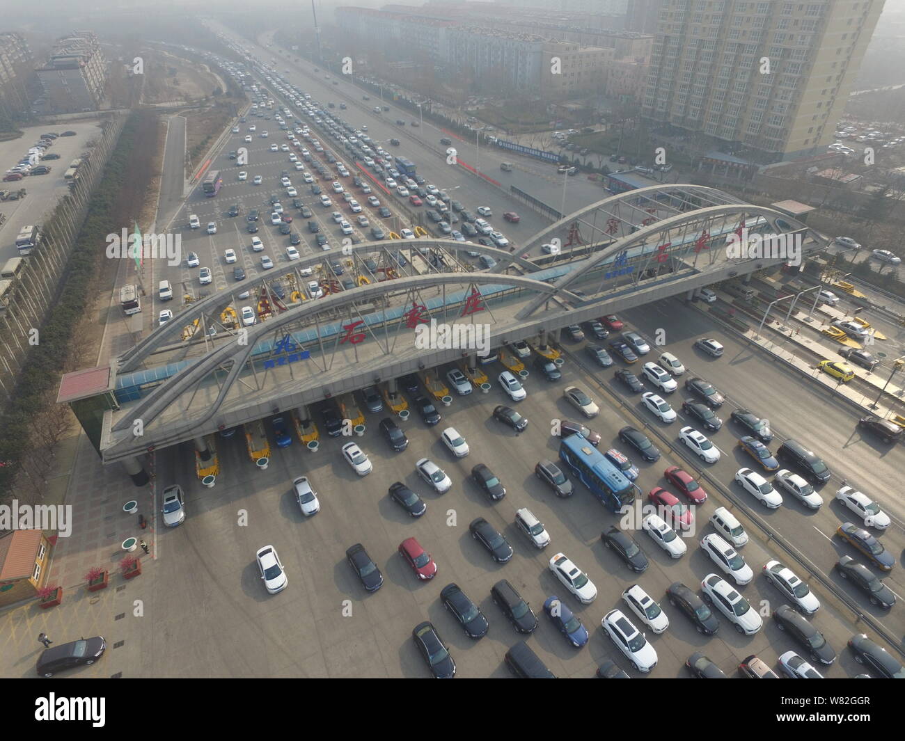 In this aerial view, masses of vehicles queue up to pass through a toll ...