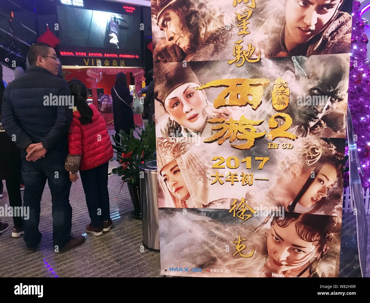 --FILE--Chinese filmgoers stand next to a poster of the movie "Journey ...
