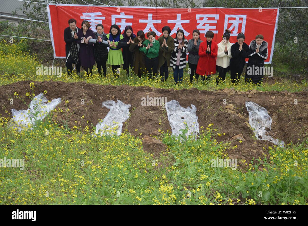 Chinese women meditate with their hands in a prayer position before ...