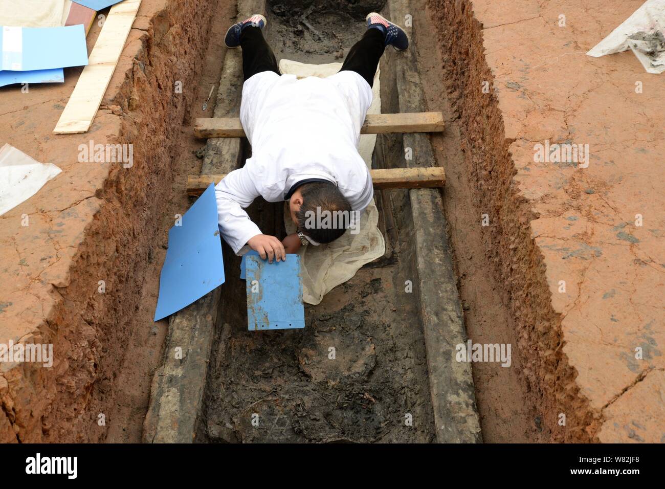 A Chinese archaeologist excavates one of the 2,200-year-old boat coffin ...