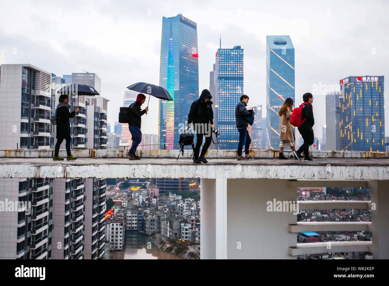 People walk on a path above old residential houses in Xiancun village ...