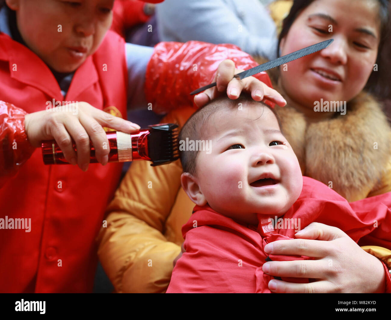A Chinese baby has his hair cut to celebrate the Longtaitou Festival ...