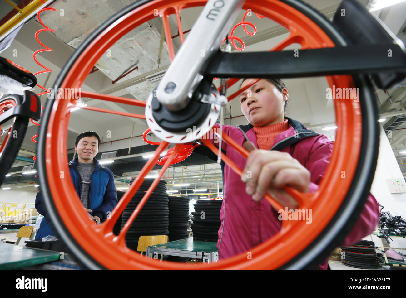 Chinese workers assemble bicycles of Chinese bike sharing service ...