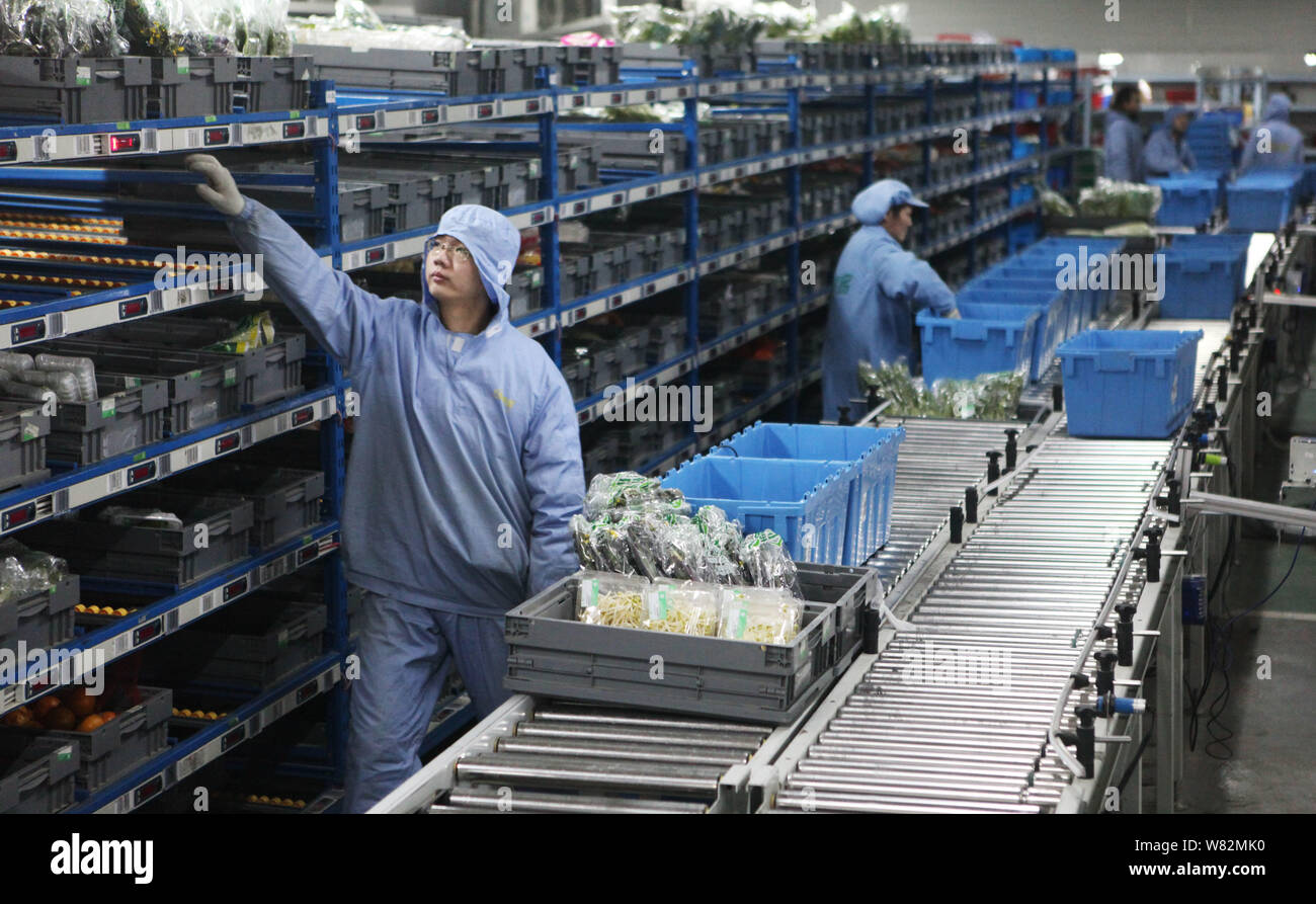 --FILE--Chinese employees dispense vegetable and other farm produce for ...