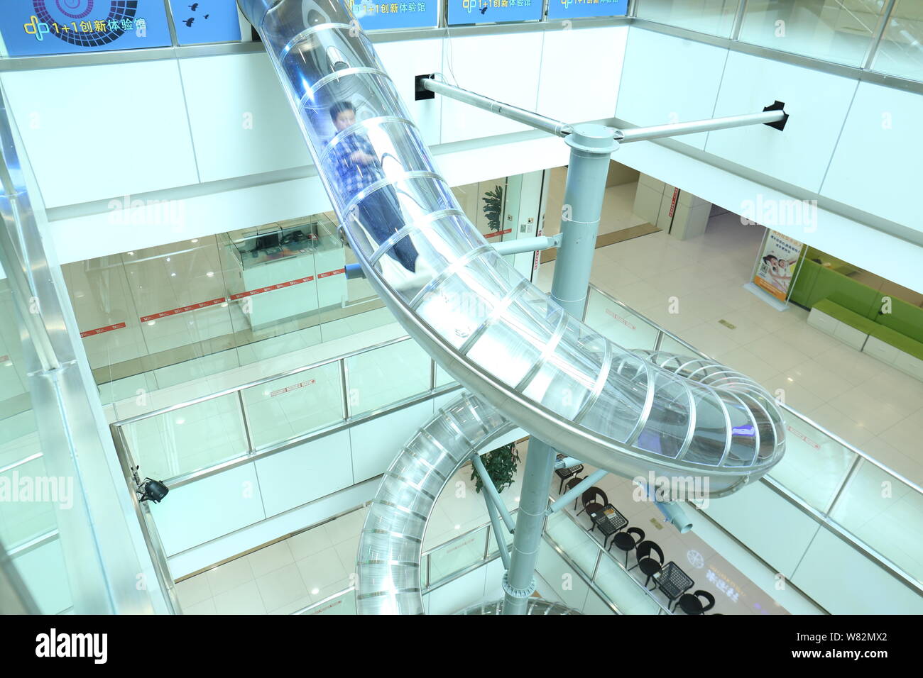 View of a man in the 16-meter tall super slide at a shopping mall in ...