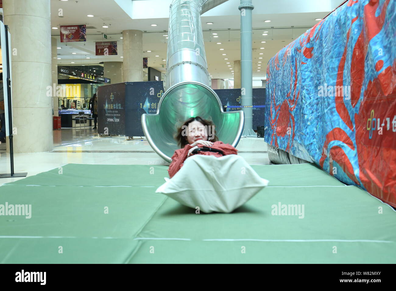 A woman tries out the 16-meter tall super slide at a shopping mall in ...