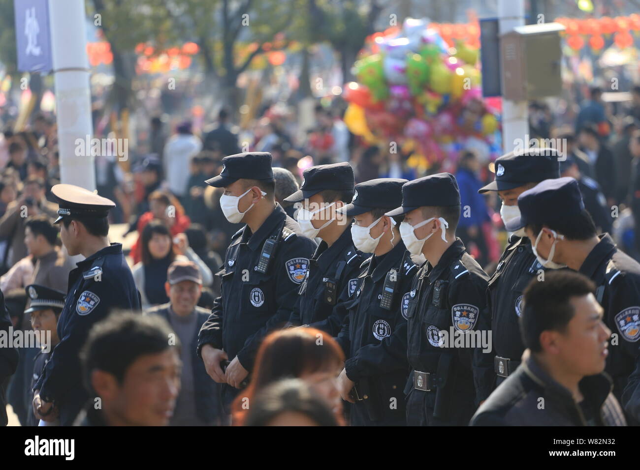 Chinese policemen wearing face masks stand guard as worshippers crowd ...