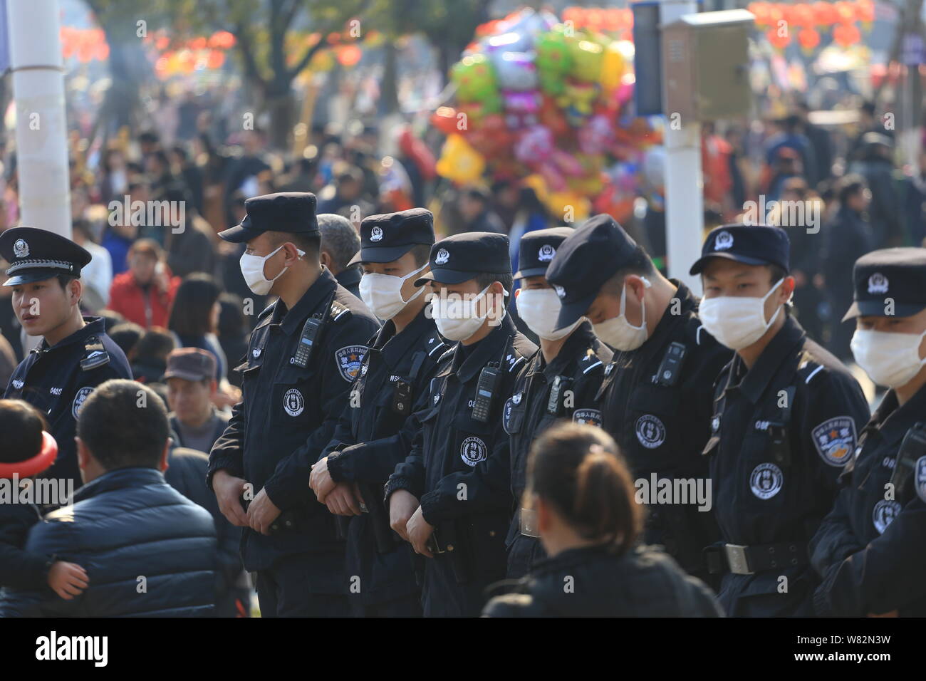 Chinese policemen wearing face masks stand guard as worshippers crowd ...