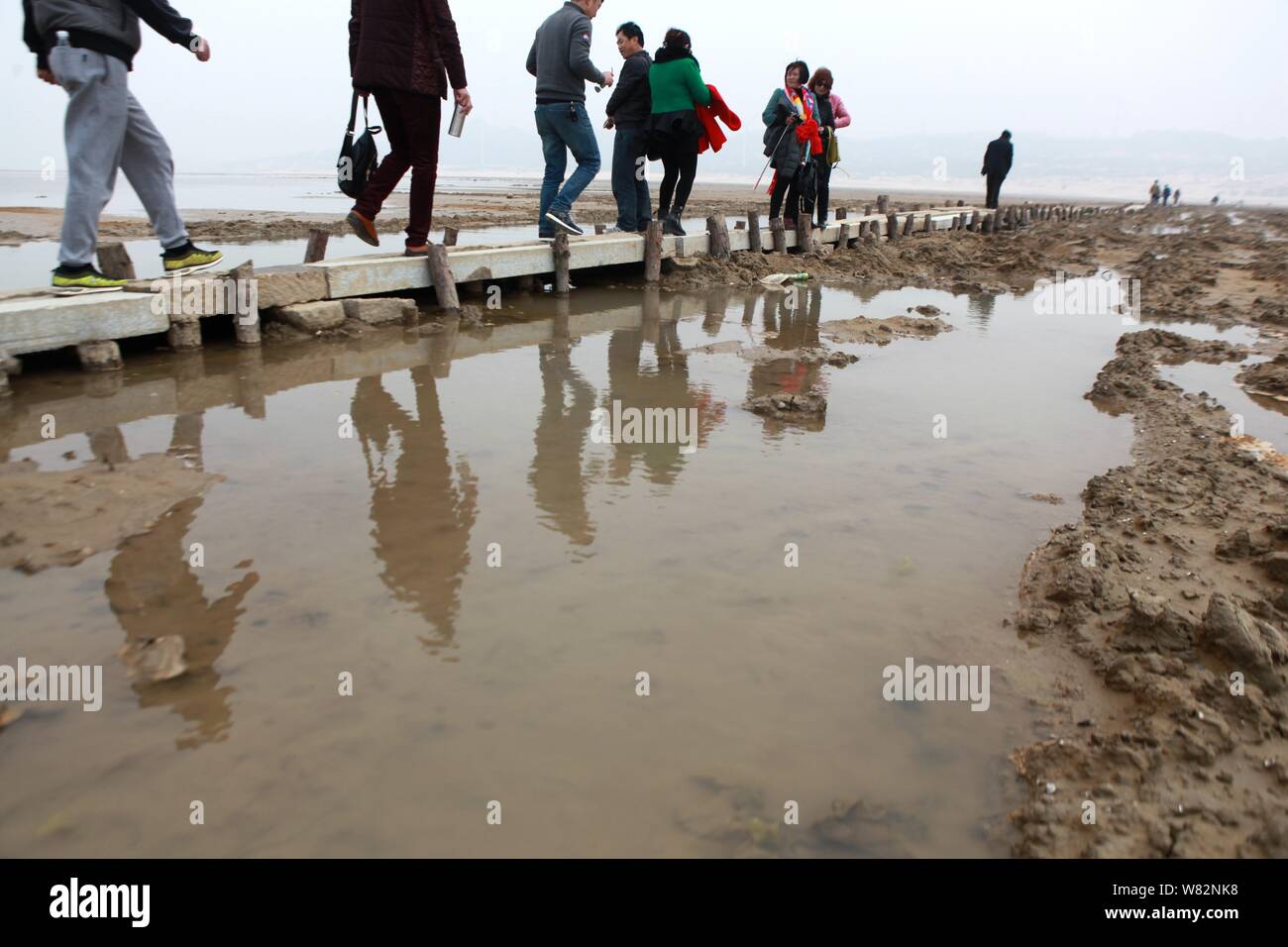 Tourists walk along the recently restored Qianyan Bridge at Poyang Lake ...