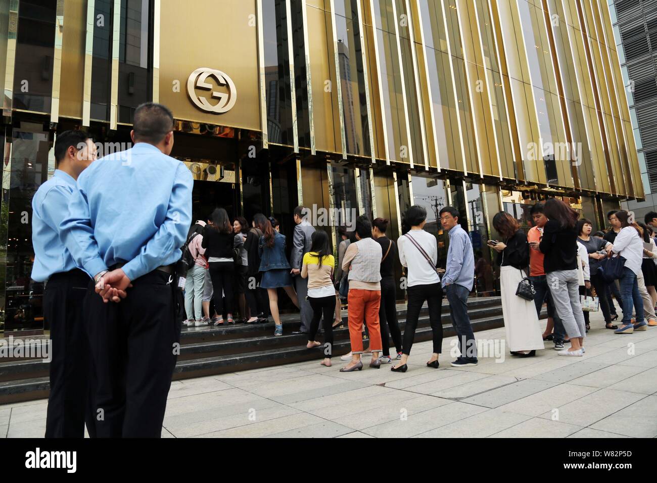 --FILE--Customers queue up outside a fashion boutique of Gucci after ...