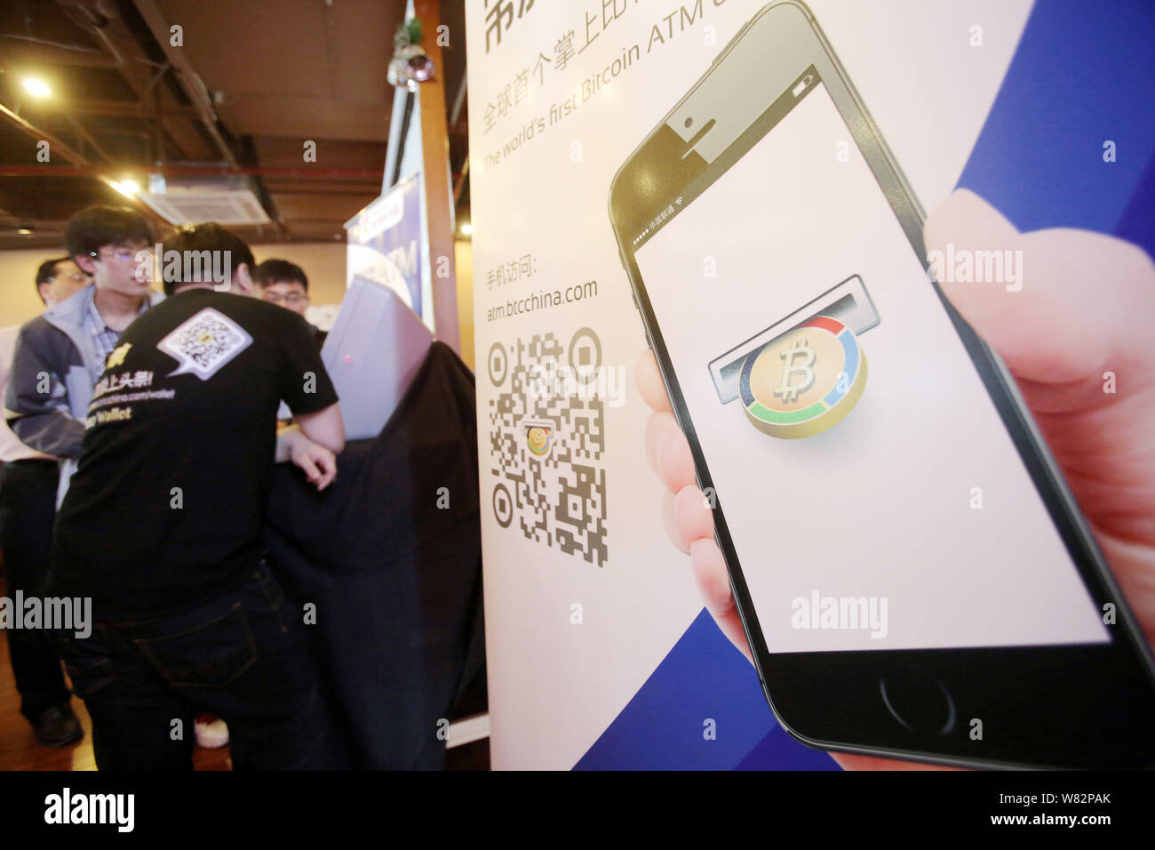 --FILE--People look at a Bitcoin ATM launched by BTC China at a cafe in ...