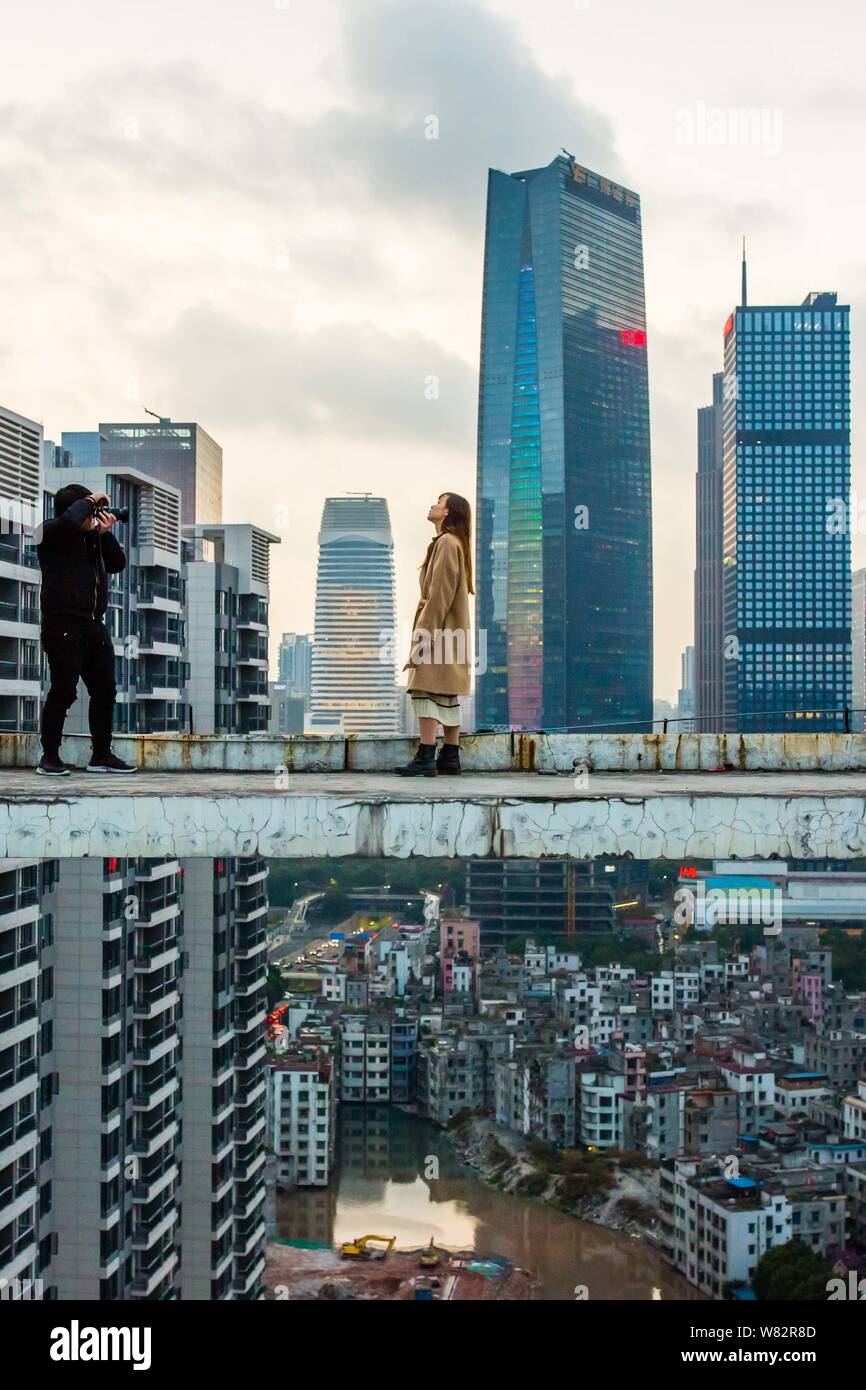 A Chinese man takes photos of a model against old residential houses in ...