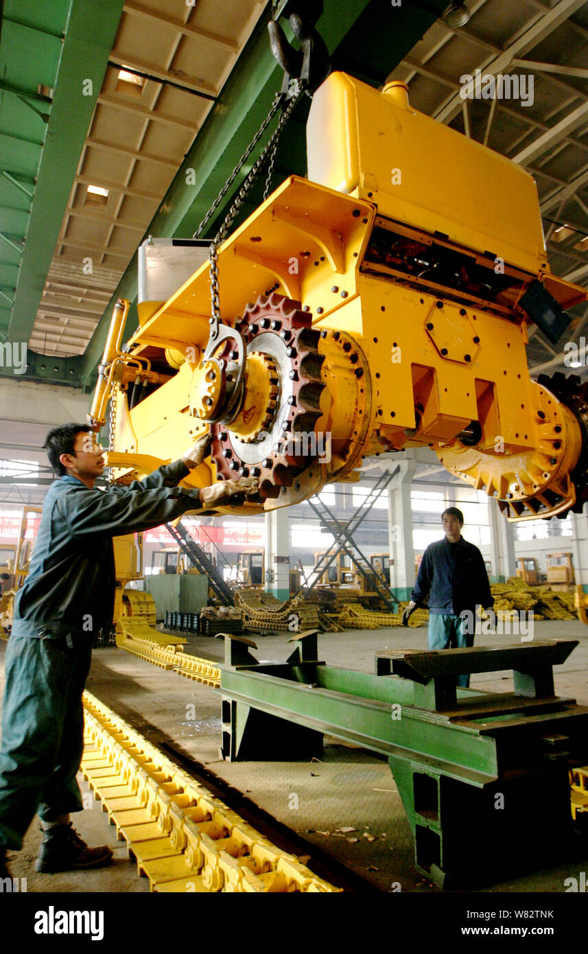 --FILE--Chinese workers assemble bulldozers on the assembly line at a ...