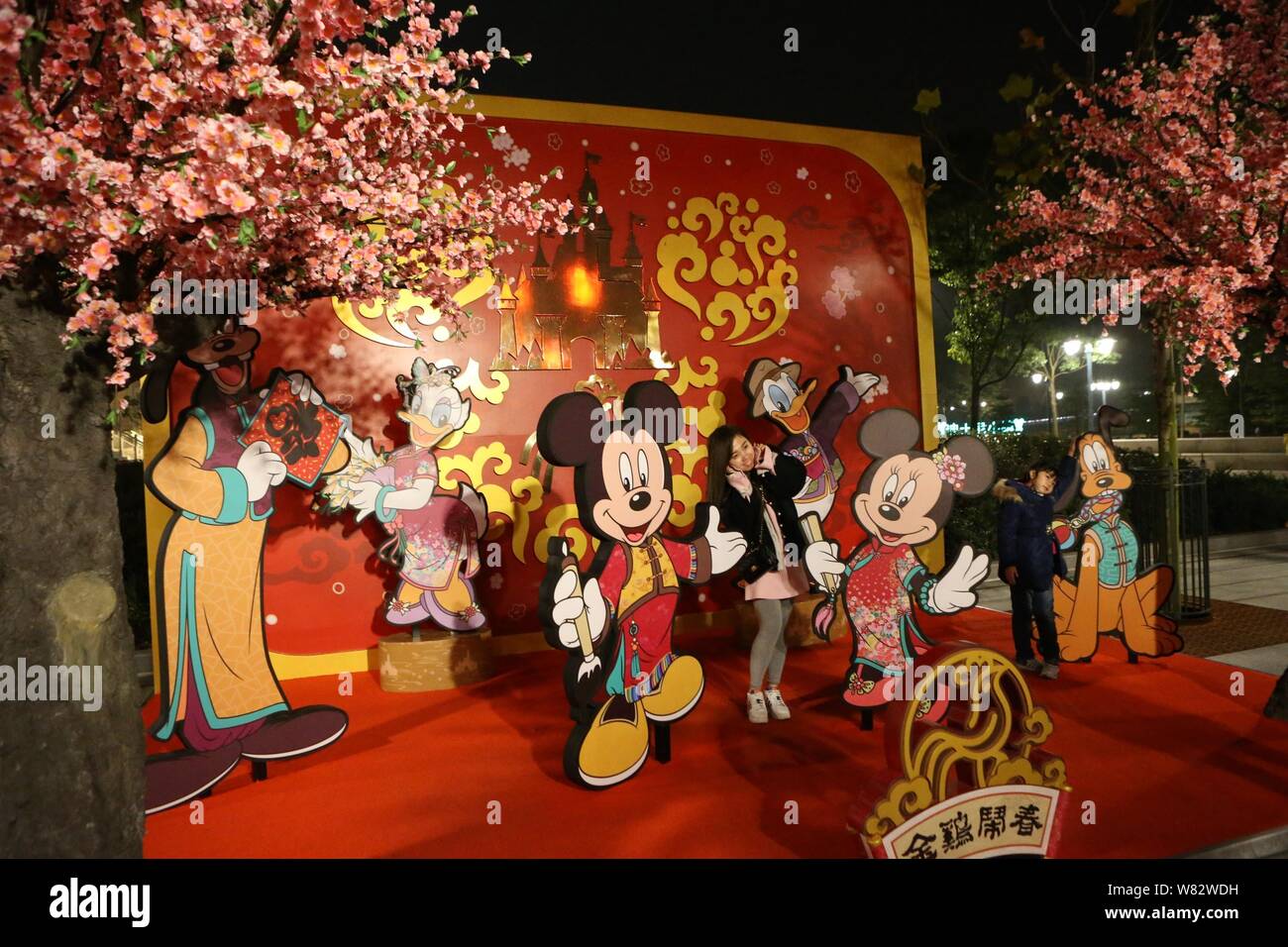 Visitors pose for photos with Disney characters dressed in traditional ...