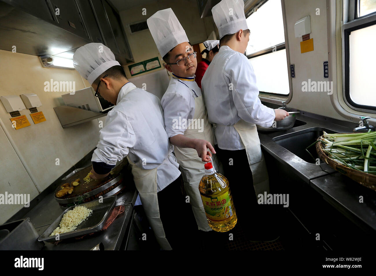 Chinese chefs prepare food in a kitchen on a train heading to Beijing ...