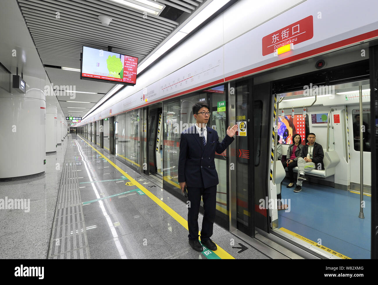 A Chinese employee guides passengers at a station of the Metro Line 1 ...