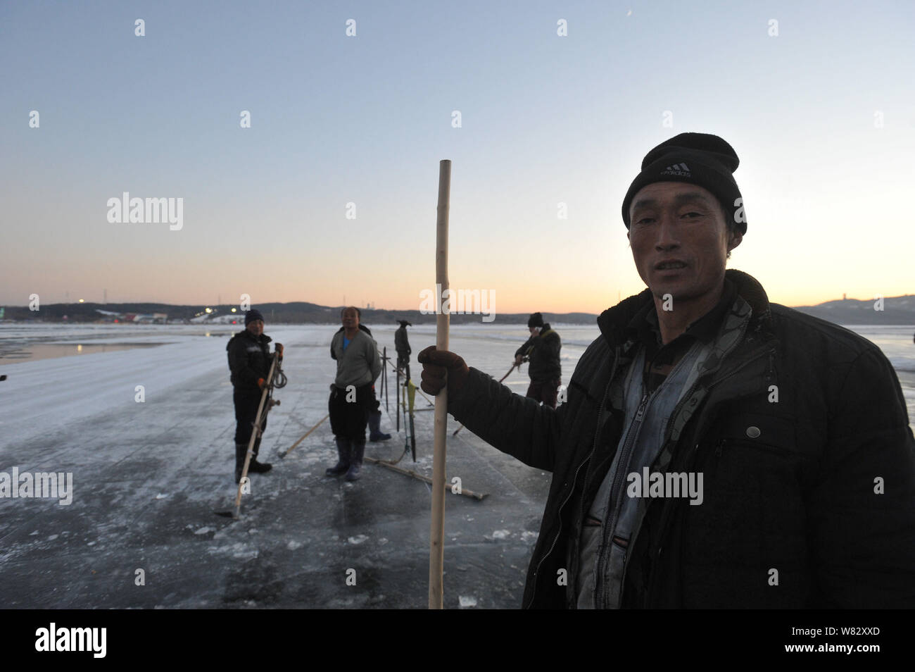 Chinese workers pose with their tools to collect ice blocks on the ...