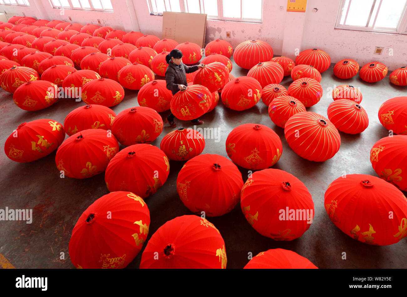 A Chinese worker checks red lanterns for the upcoming Chinese New Year ... A Chinese worker checks red lanterns for the upcoming Chinese New Year ...