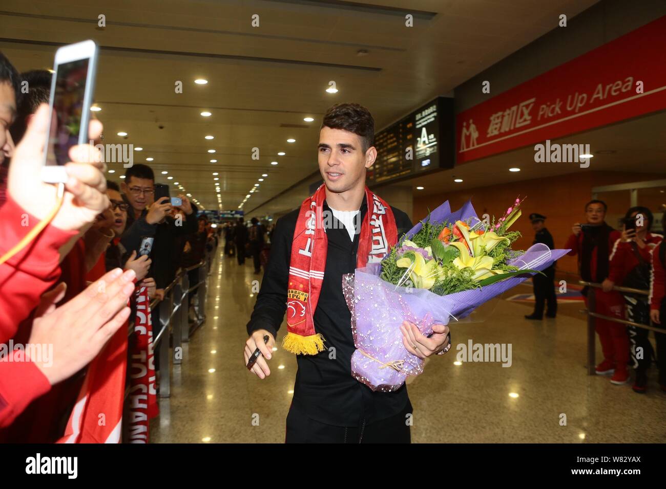Brazilian football player Oscar is pictured after arriving at the Shanghai Pudong International ...