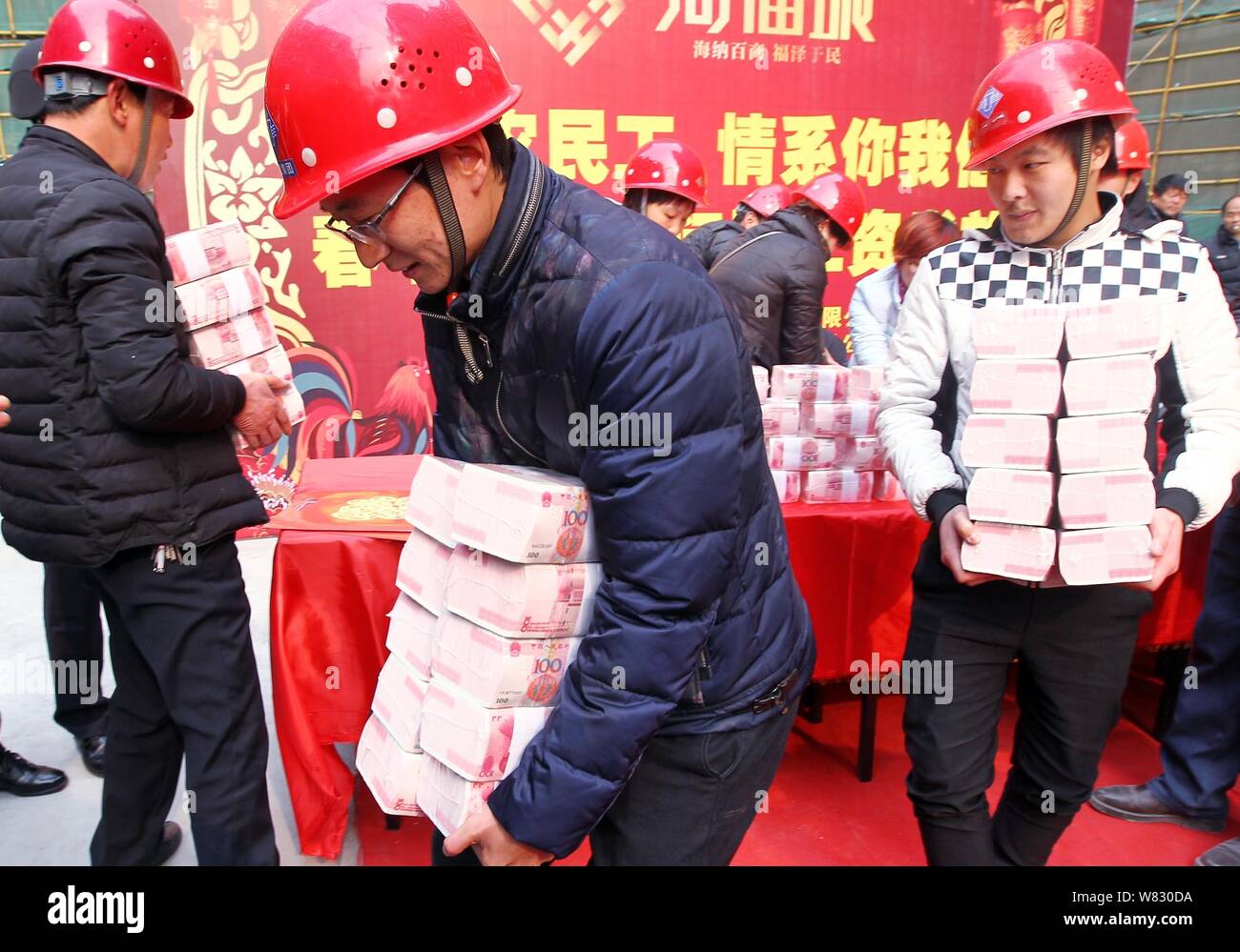 Chinese migrant workers get bundles of 100-yuan RMB (Renminbi ...