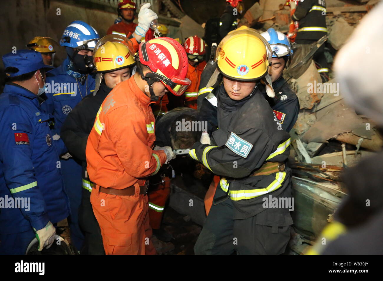 Chinese rescuers carry a survivor after he was pulled out of debris of ...