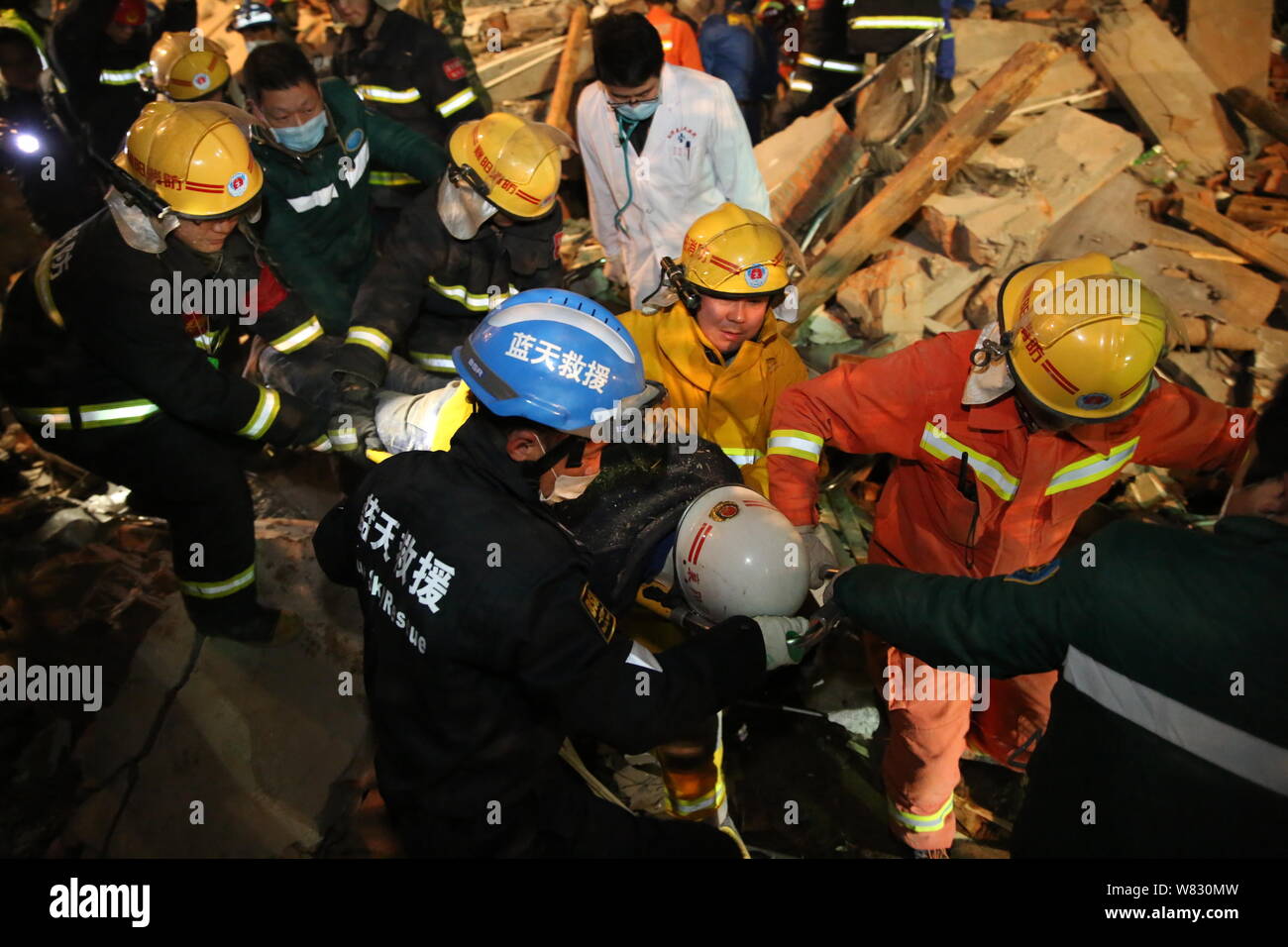 Chinese rescuers carry a survivor after he was pulled out of debris of ...