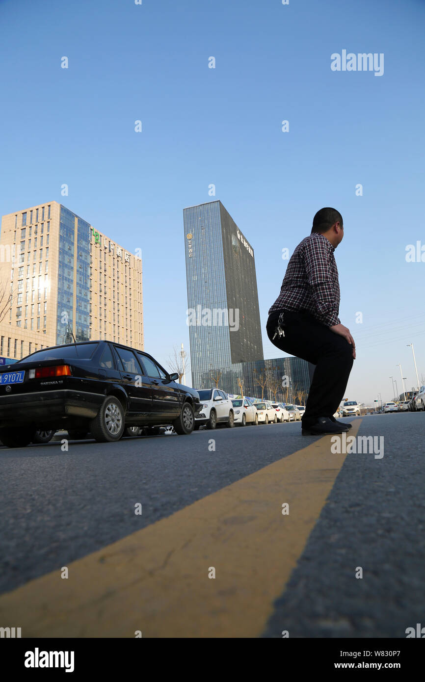 A pedestrian tries to "sit" on a chair-shaped building in Zhengzhou ...