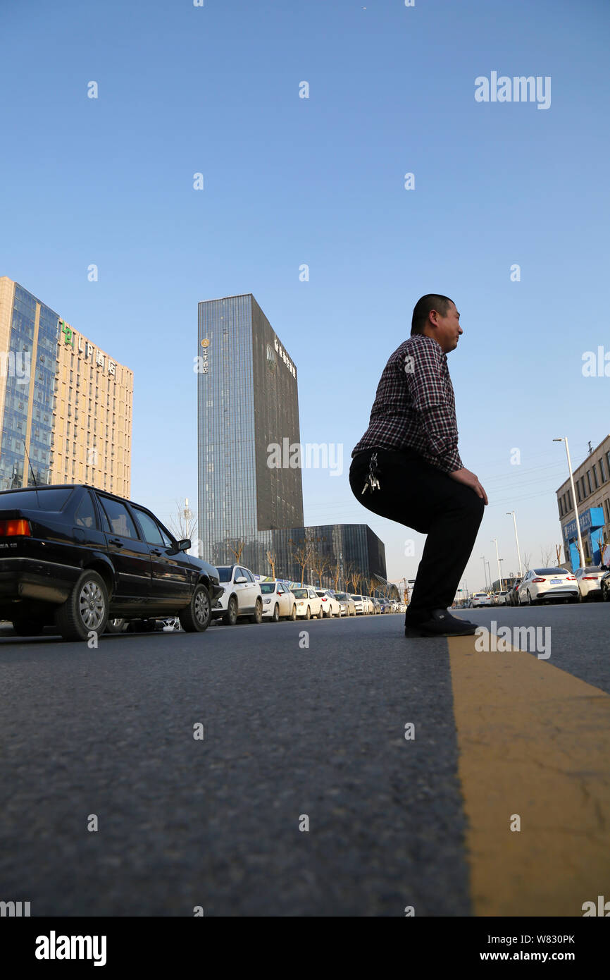 A pedestrian tries to "sit" on a chair-shaped building in Zhengzhou ...