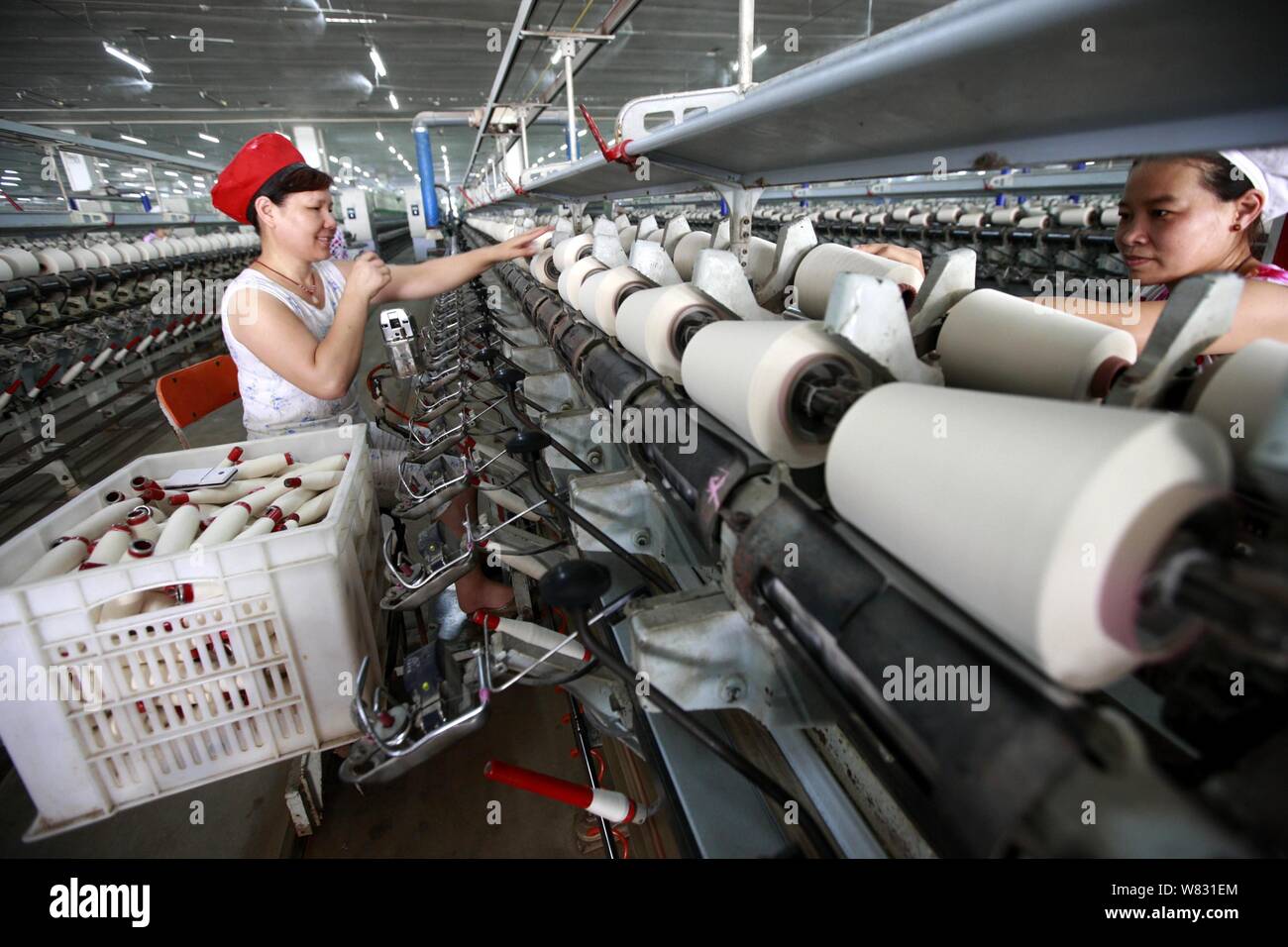 --FILE--Female Chinese workers handle production of yarn at a textile factory in Huaibei city ...