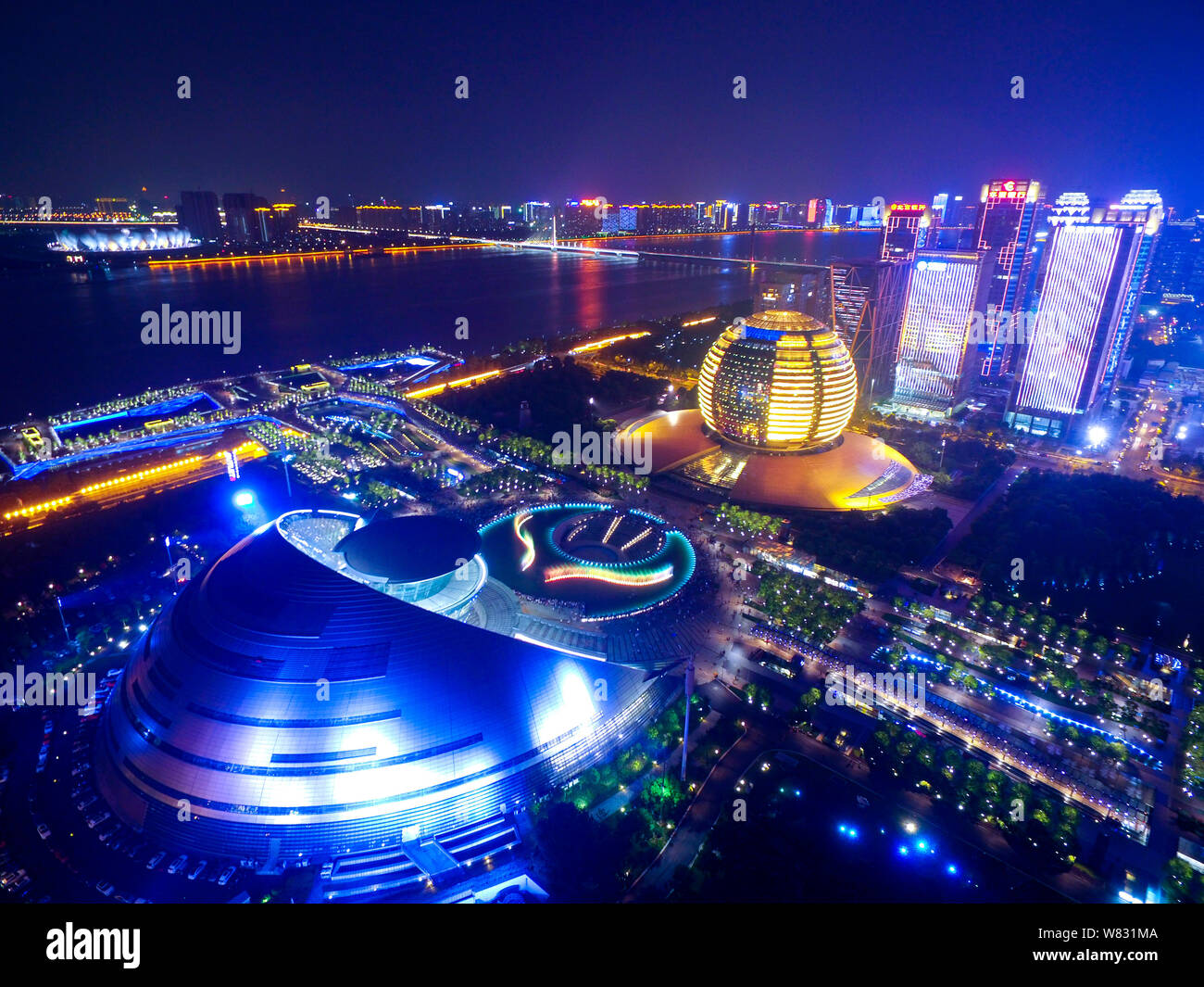 Night view of the Hangzhou Grand Theatre, front, the InterContinental Hotel Hangzhou, in yellow ...