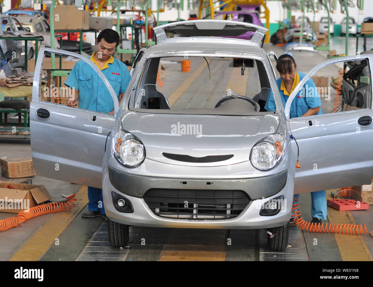 --FILE--Chinese workers assemble an electric car on the assembly line ...