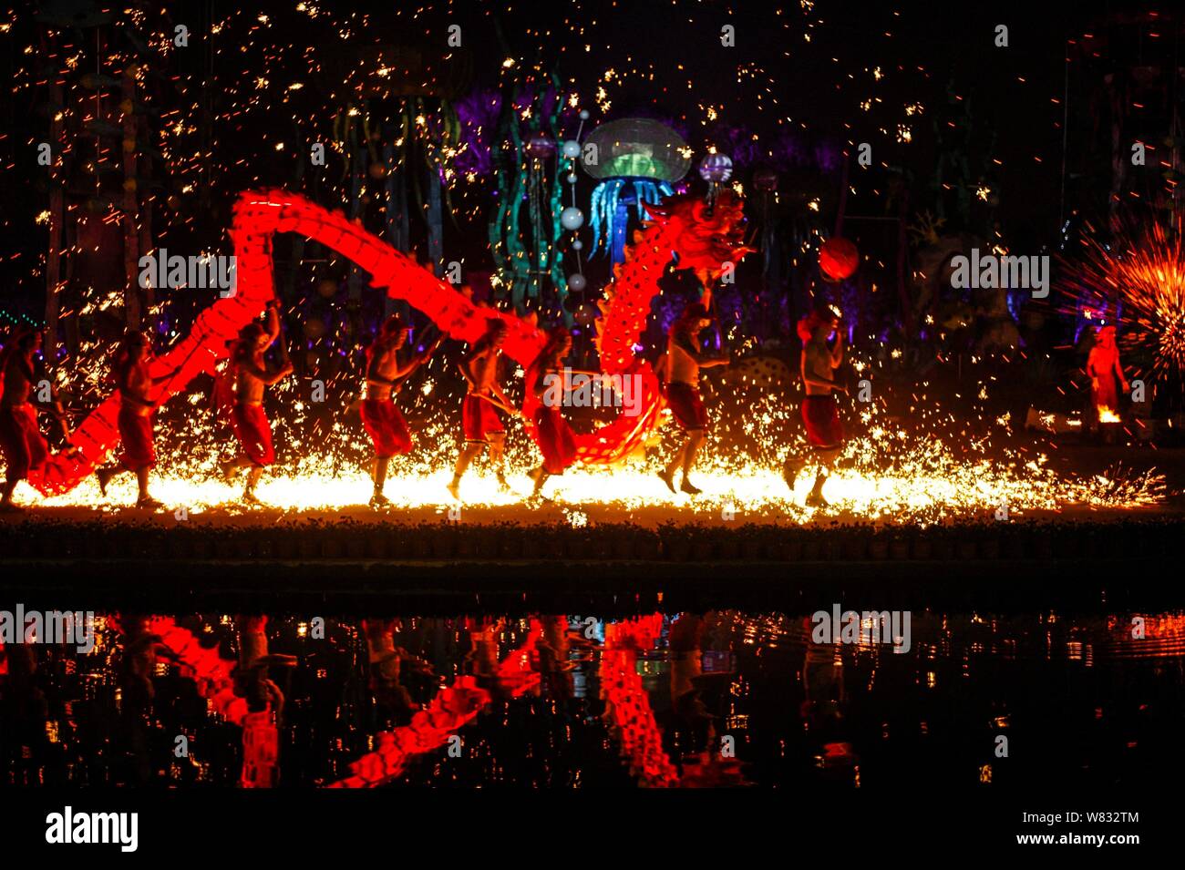Chinese entertainers perform a fire dragon dance in a shower of molten ...