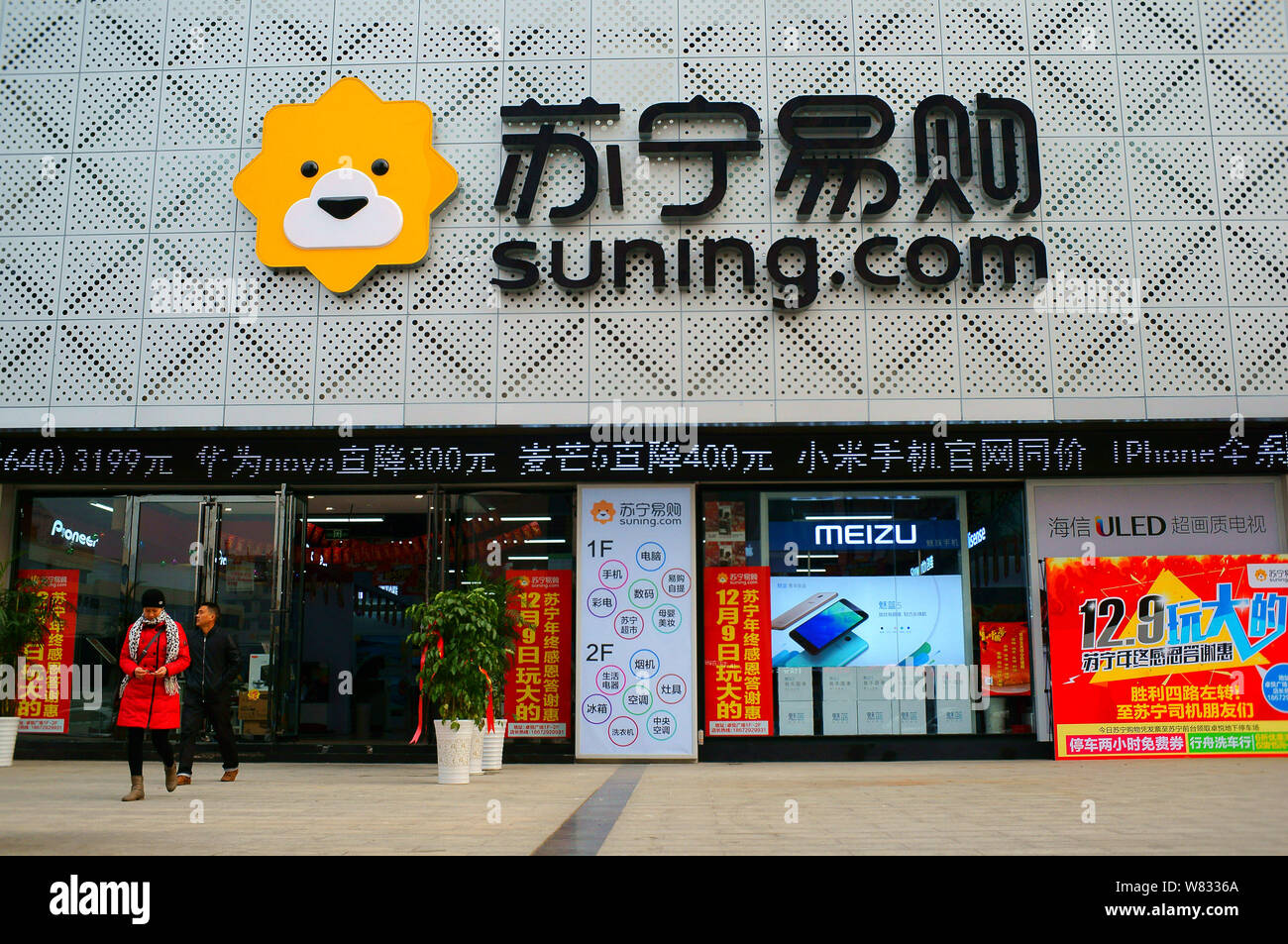 --FILE--Pedestrians walk past a store of Suning.com, the online ...
