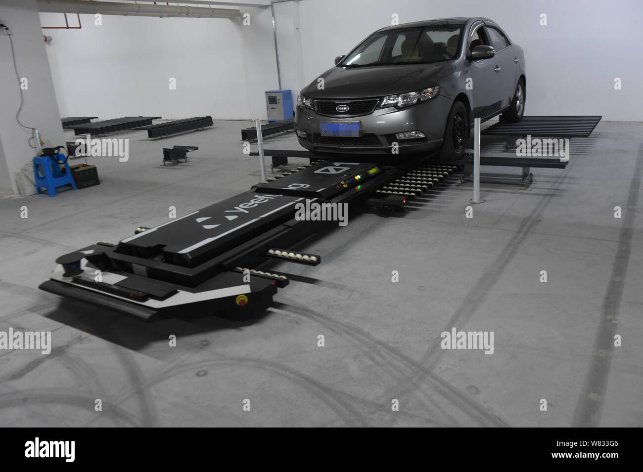 An automated guided vehicle robot leaves after transferring a car into ...